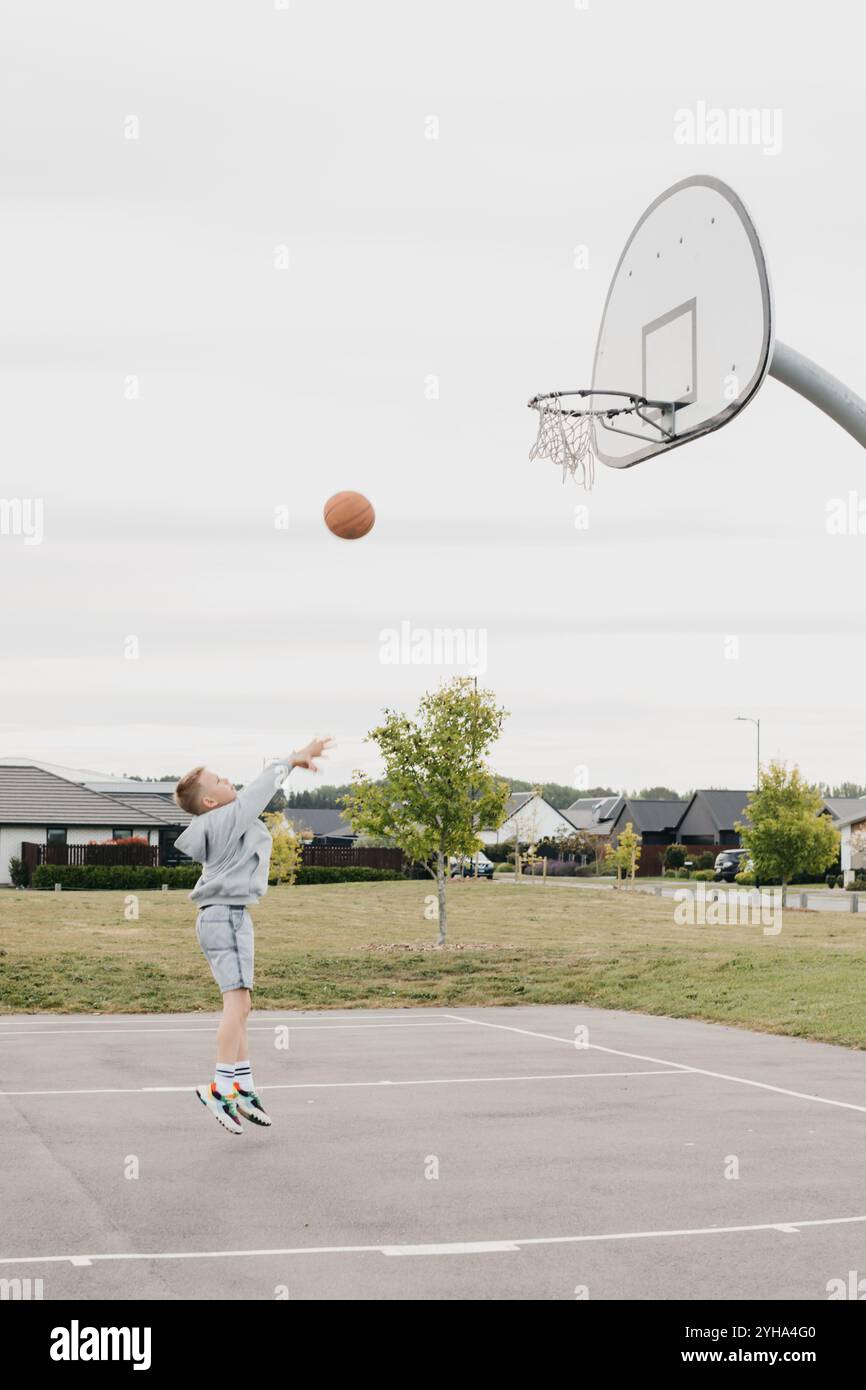 Teenage boy hits goal playing basketball on village sports ground Stock ...