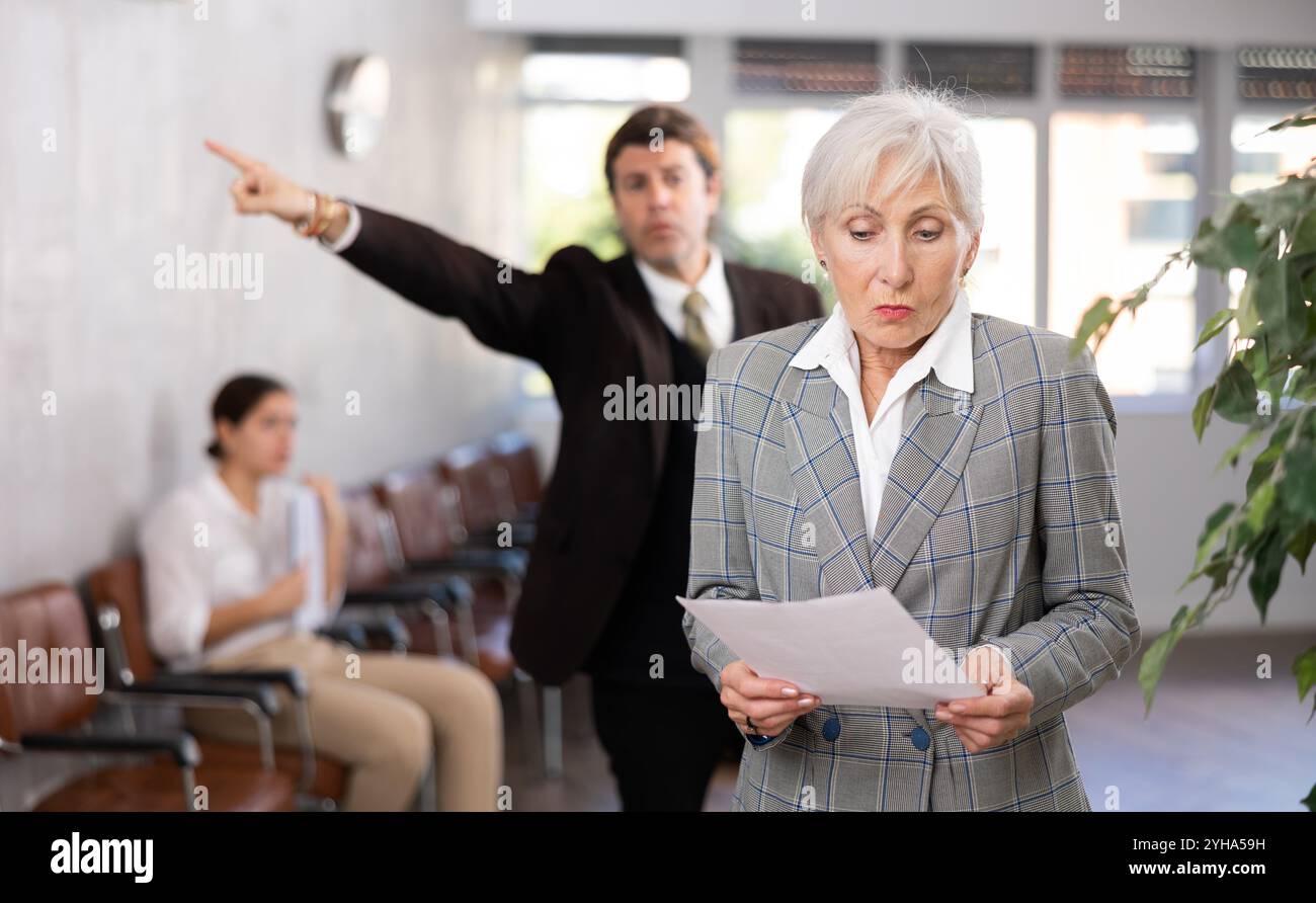 Upset senior businesswoman with displeased boss pointing at door Stock ...