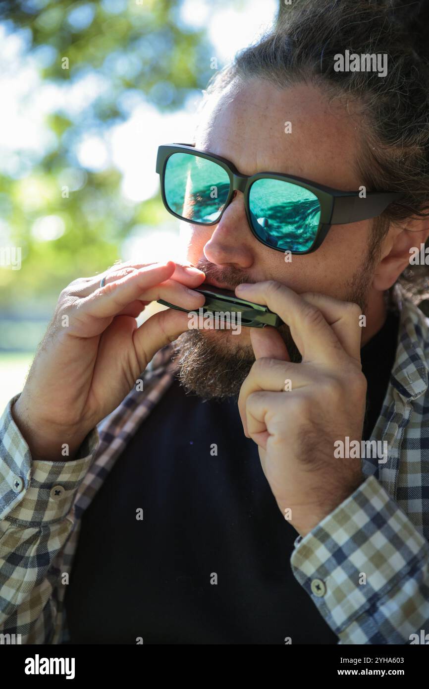 Man Wearing Sunglasses Playing Harmonica, Mouth Organ Stock Photo - Alamy