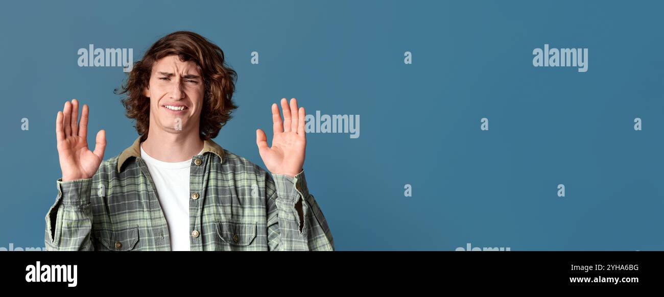 Millennial guy with disgusted face showing denial gesture on color ...
