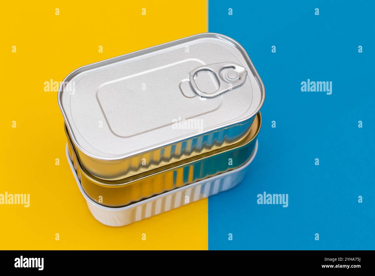A Group of Stacked Tin Cans on Split Blue and Yellow Background. Canned ...