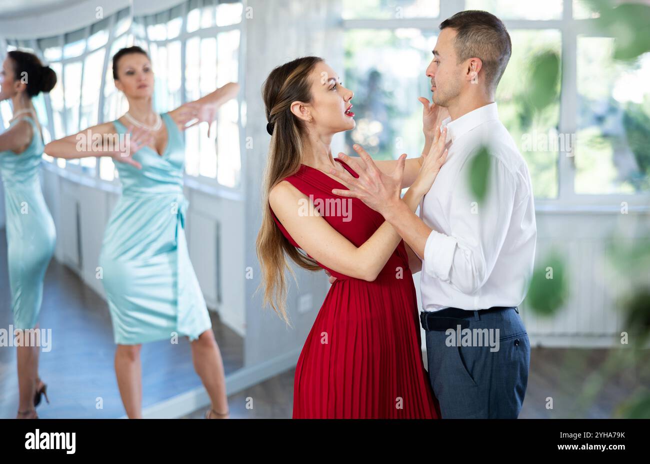 Couple in stage costumes learns tango dancing during individual lesson ...
