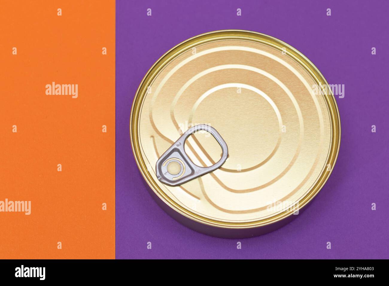 Unopened Tin Can on Split Orange and Violet Background. Canned Food ...