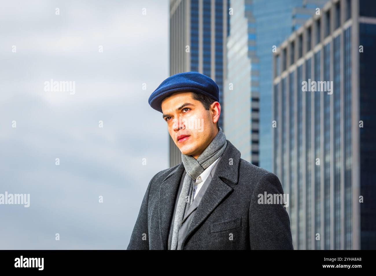 A man dressed in a gray coat and blue flat cap gazes thoughtfully, with ...