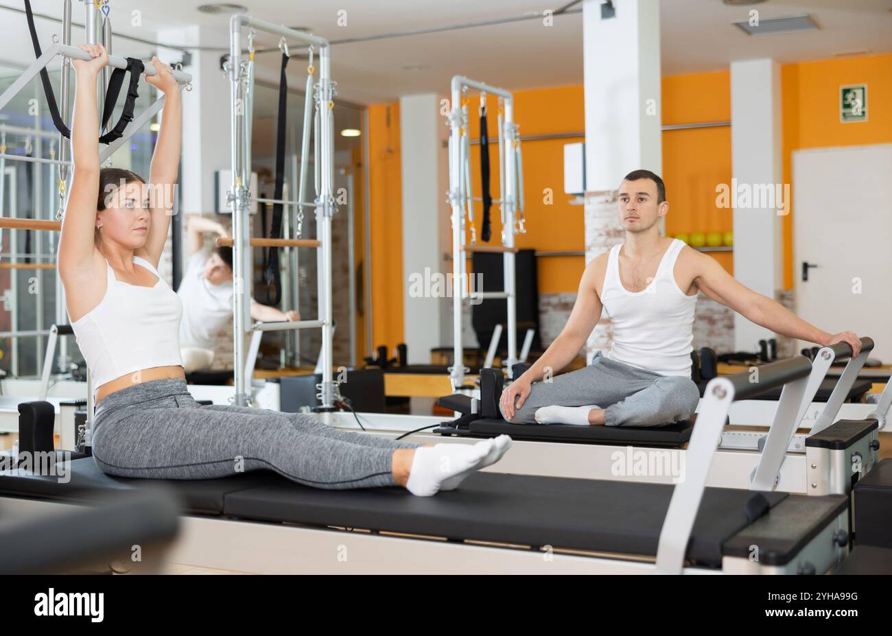 Man in gym with help of rope reformer performs exercises to strengthen ...