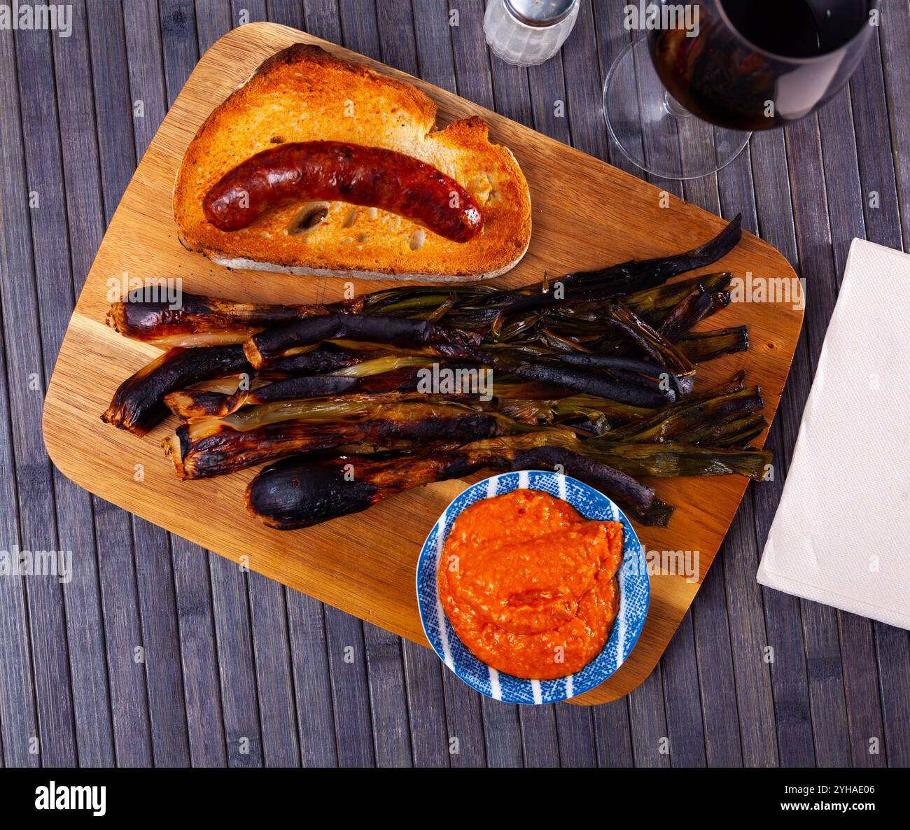 Calcot with romesco sauce and grilled botifarra Stock Photo - Alamy