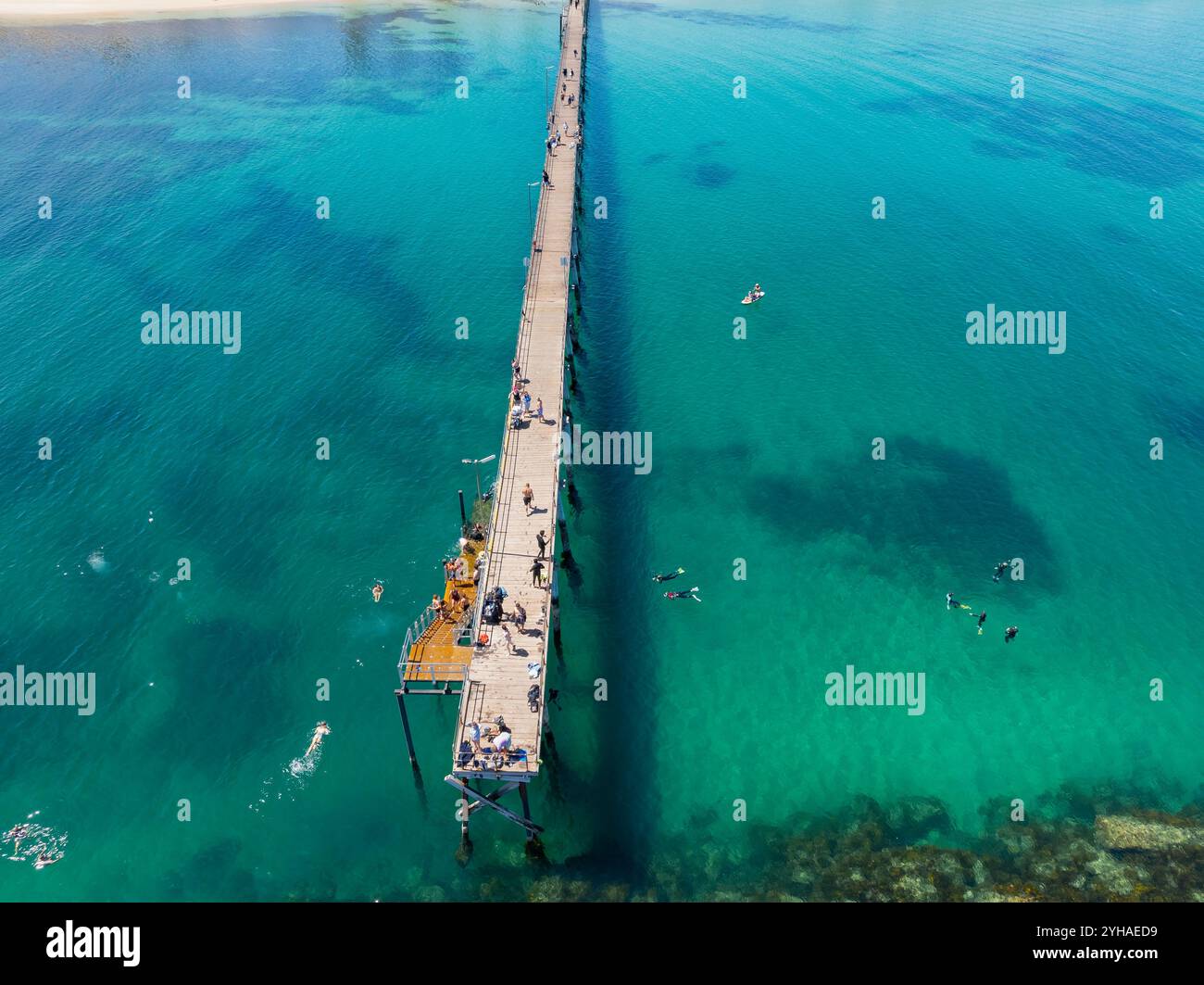 Aerial view of beach goers on the end of a long wooden jetty at Port ...