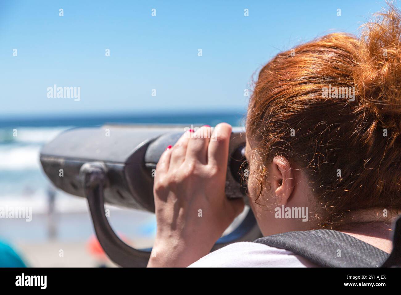 Young cute woman looking at skyline and cityscape through Coin operated ...