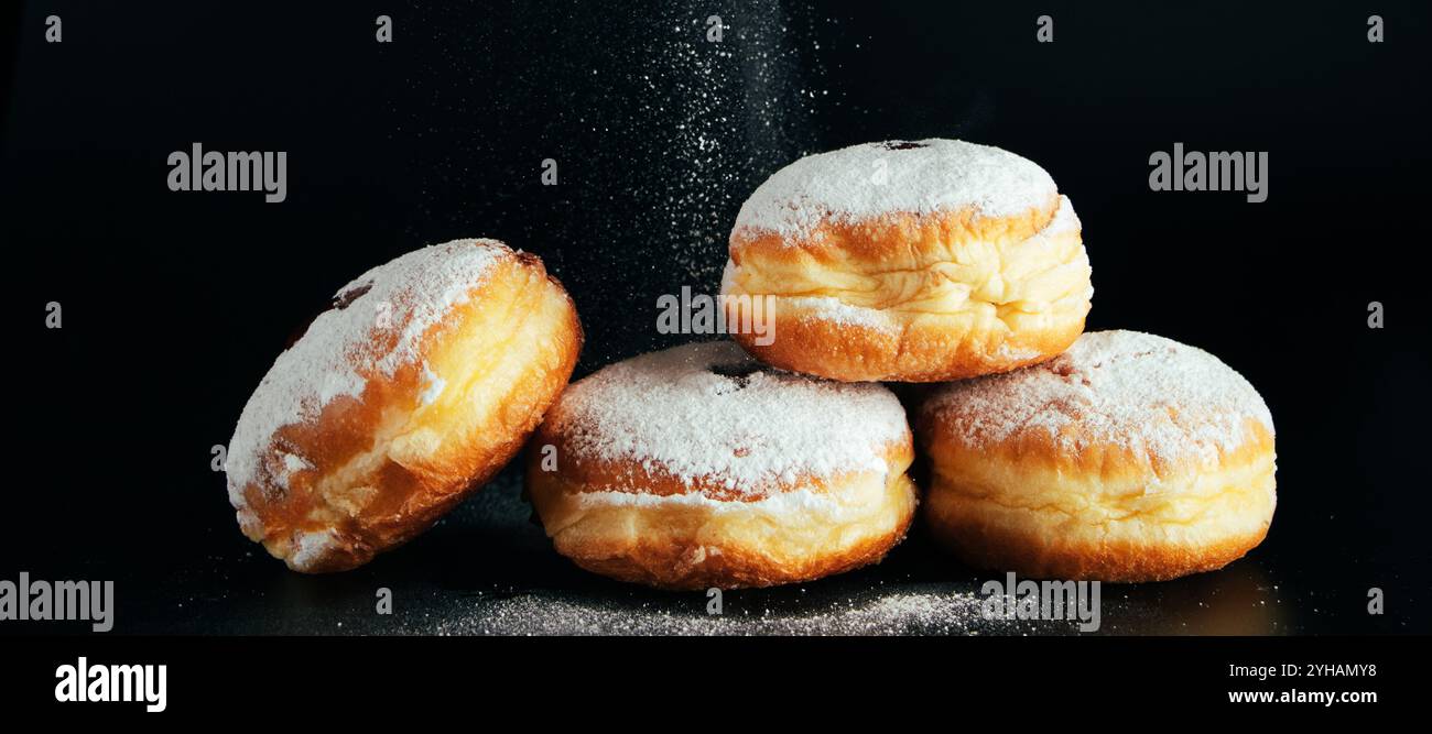 Powdered sugar is poured onto donuts. Traditional Jewish dessert ...