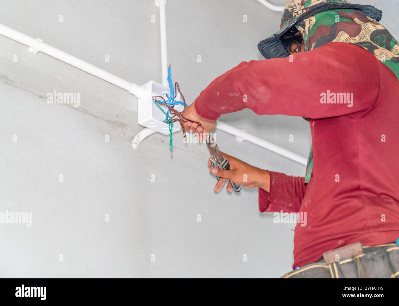 Man tie a wire tie at junction box for new building in construction ...