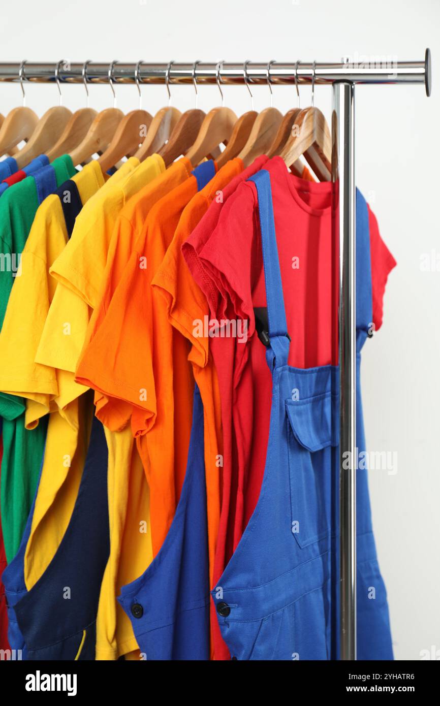 Workers' uniforms on clothing rack near grey wall indoors Stock Photo ...