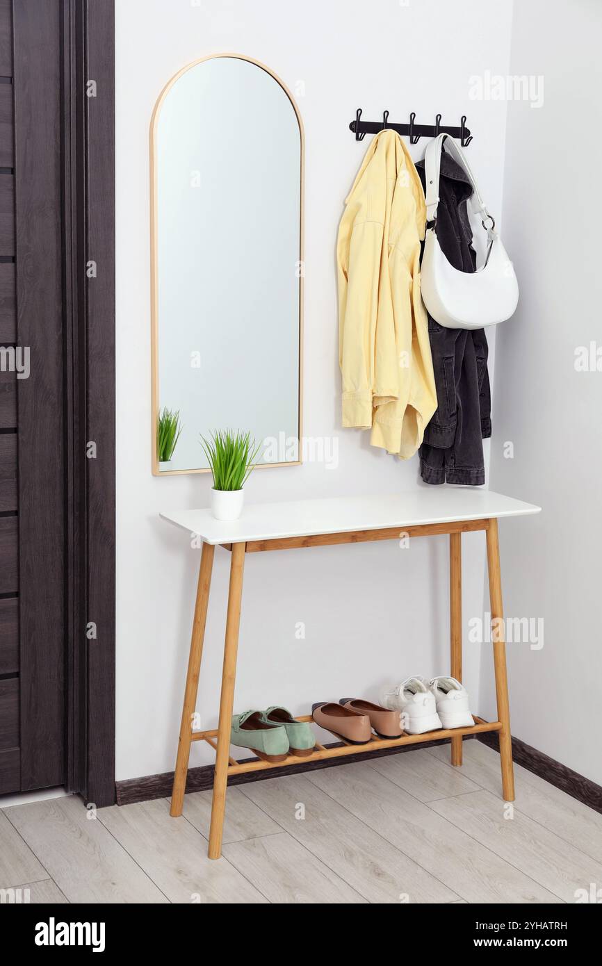 Mirror, rack with clothes and shoe storage bench in hallway. Interior ...