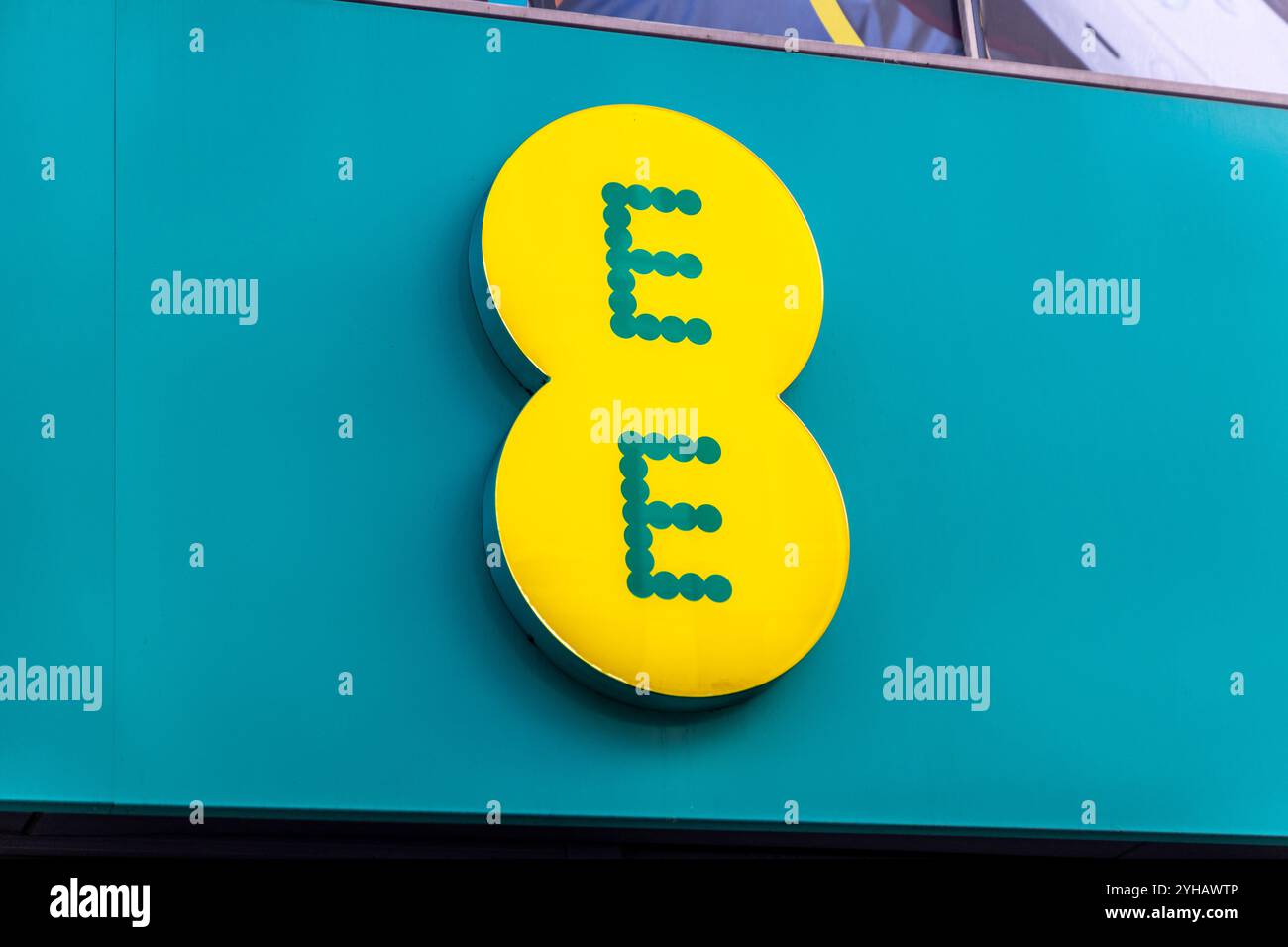 London, UK- September 19, 2024: Bright Yellow EE Logo on Vibrant Teal ...