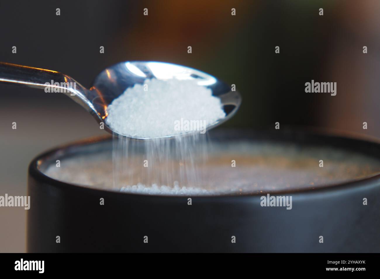 white sugar pouring from a in a paper packet on a coffee cup Stock ...