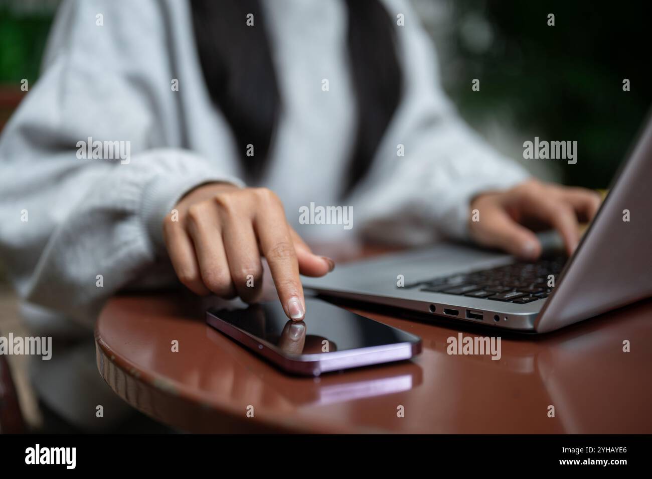 A close-up of a woman tapping on her smartphone screen, checking ...