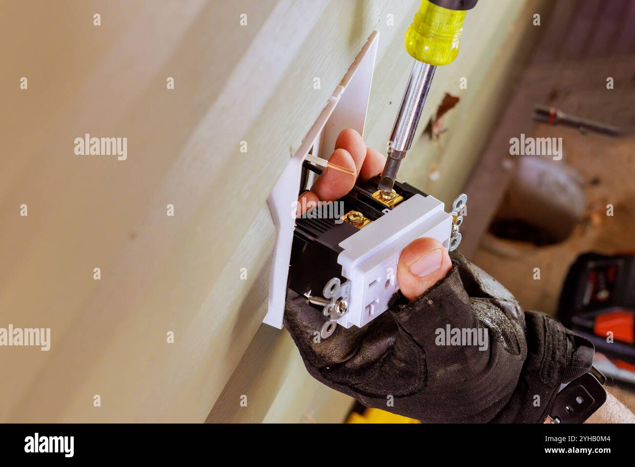 During installation of new outlet, electrical wires are connected to ...