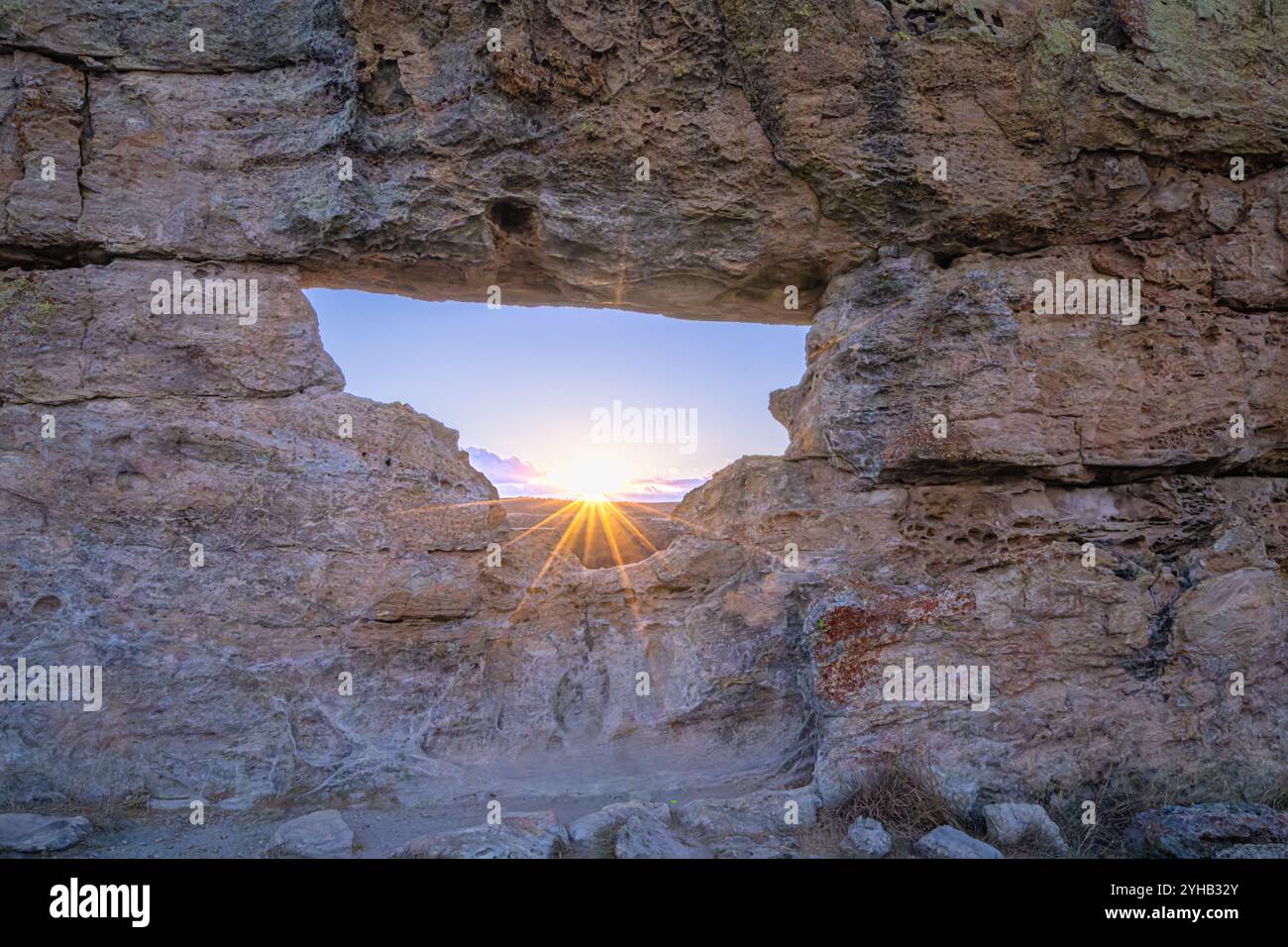 Spectacular sunburst piercing through natural rock formation with ...