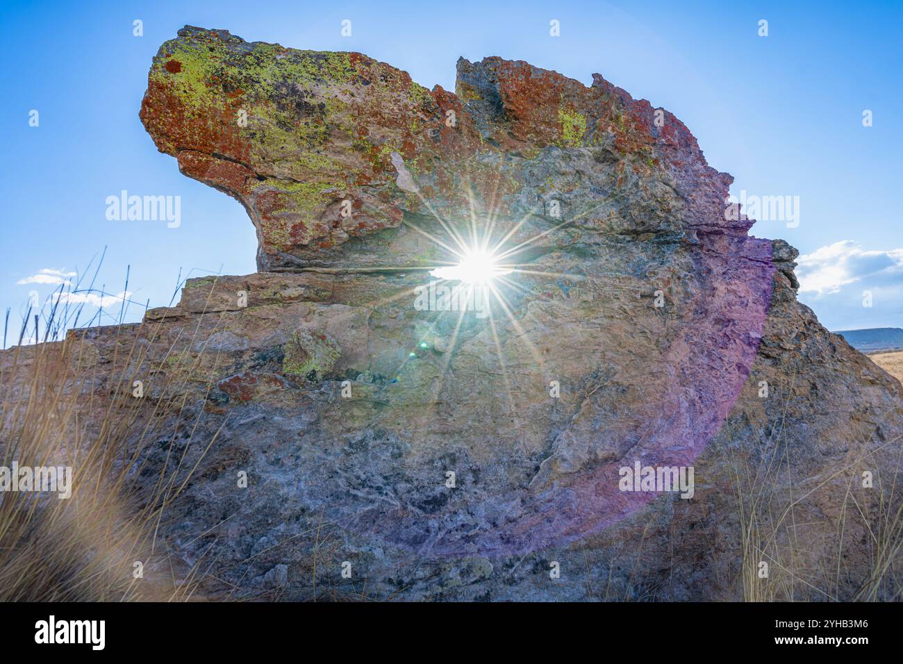 Spectacular sunburst piercing through natural rock formation with ...