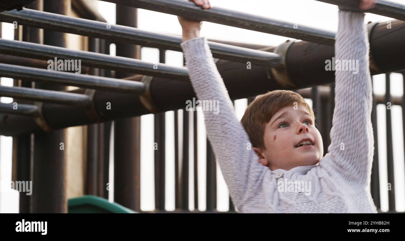 Boy, child and monkey bars at playground, outdoor and adventure with ...