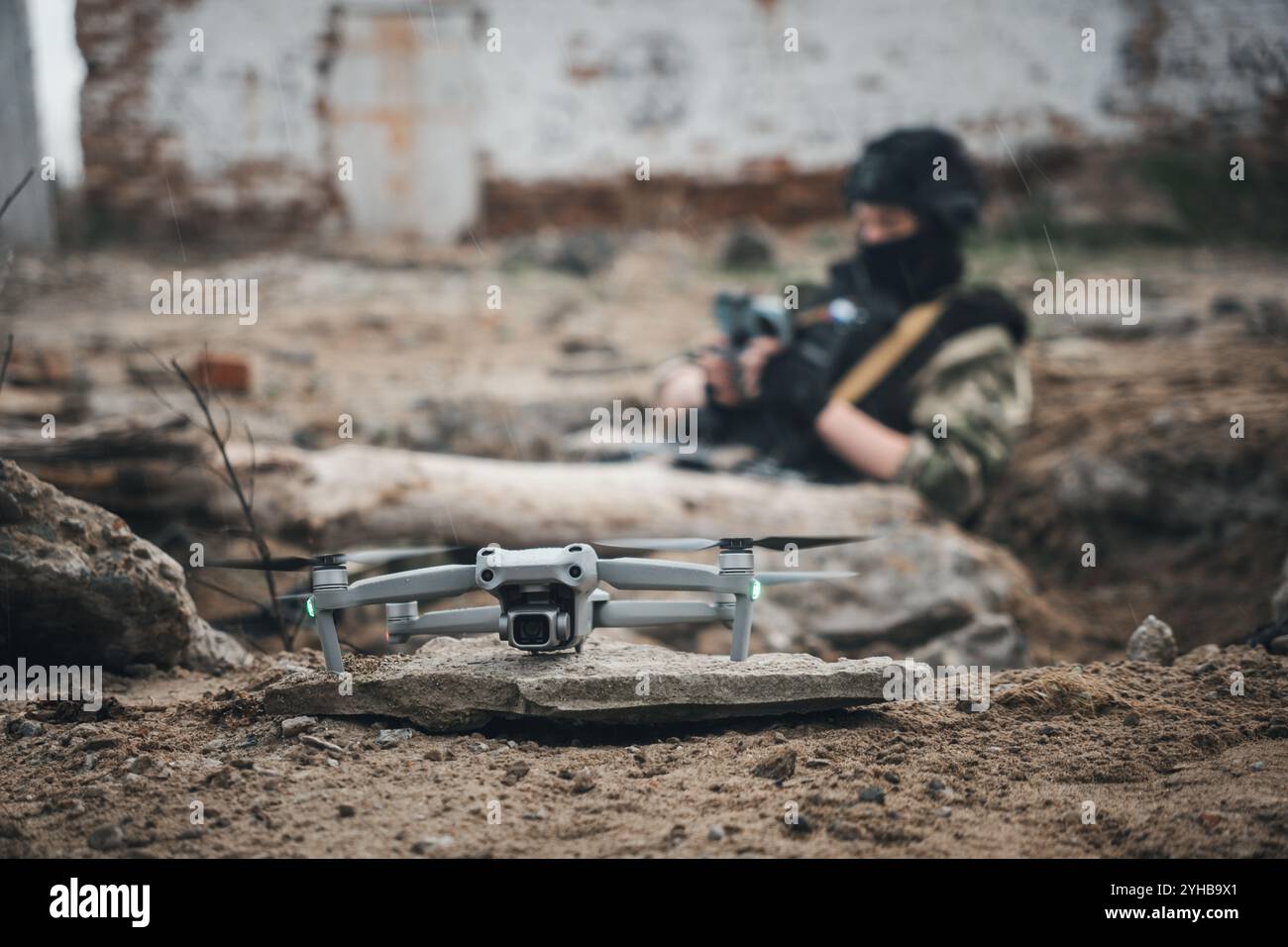 UAV operator with a remote control sitting in a trench. The concept of ...