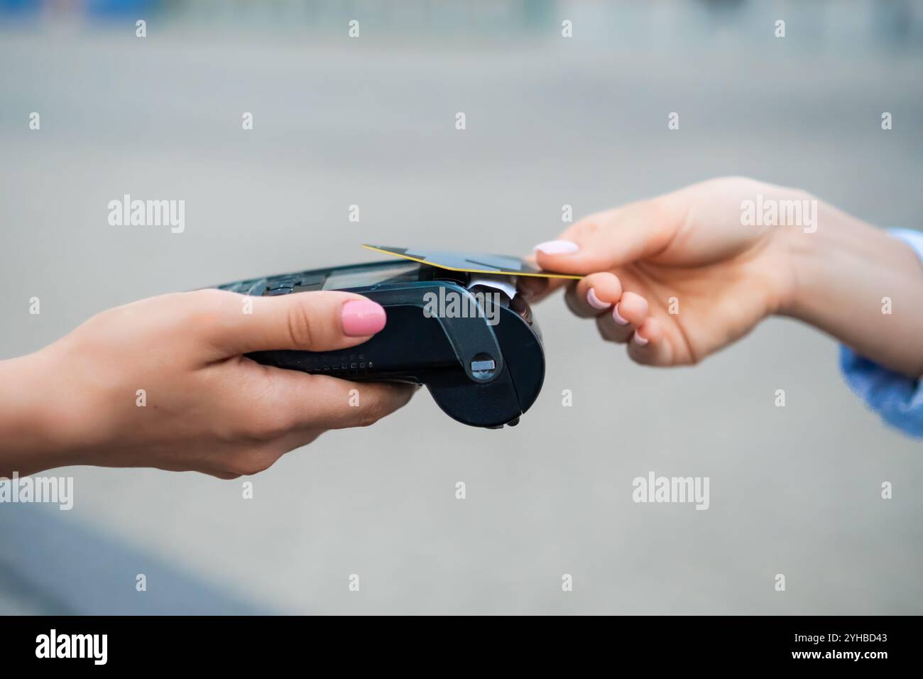 Customer using a payment terminal for contactless transaction at ...