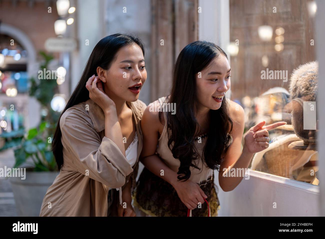 Two charming and excited Asian female friends enjoy shopping together ...