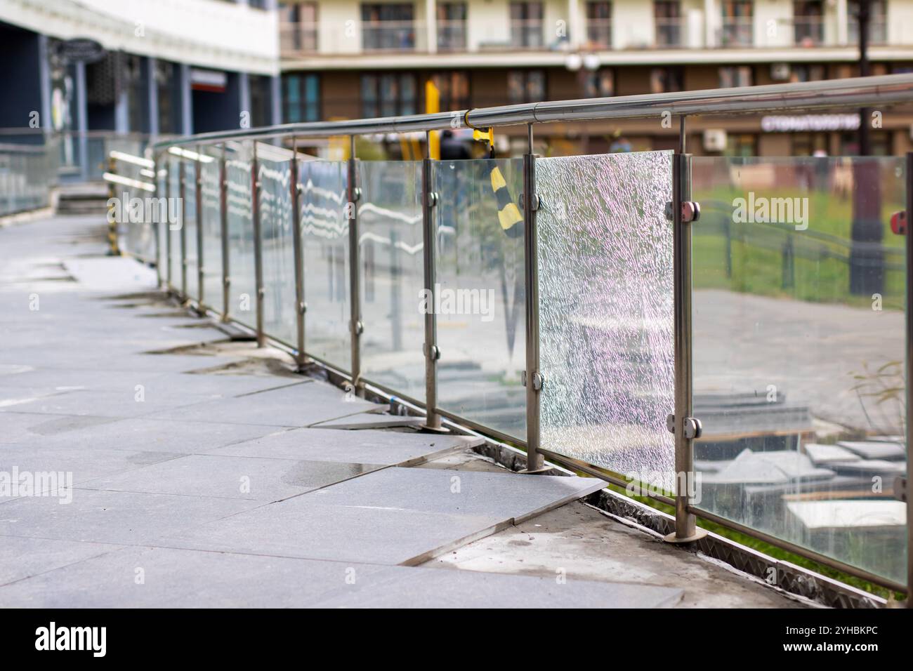 A stainless steel railing featuring a glass panel installed on it ...