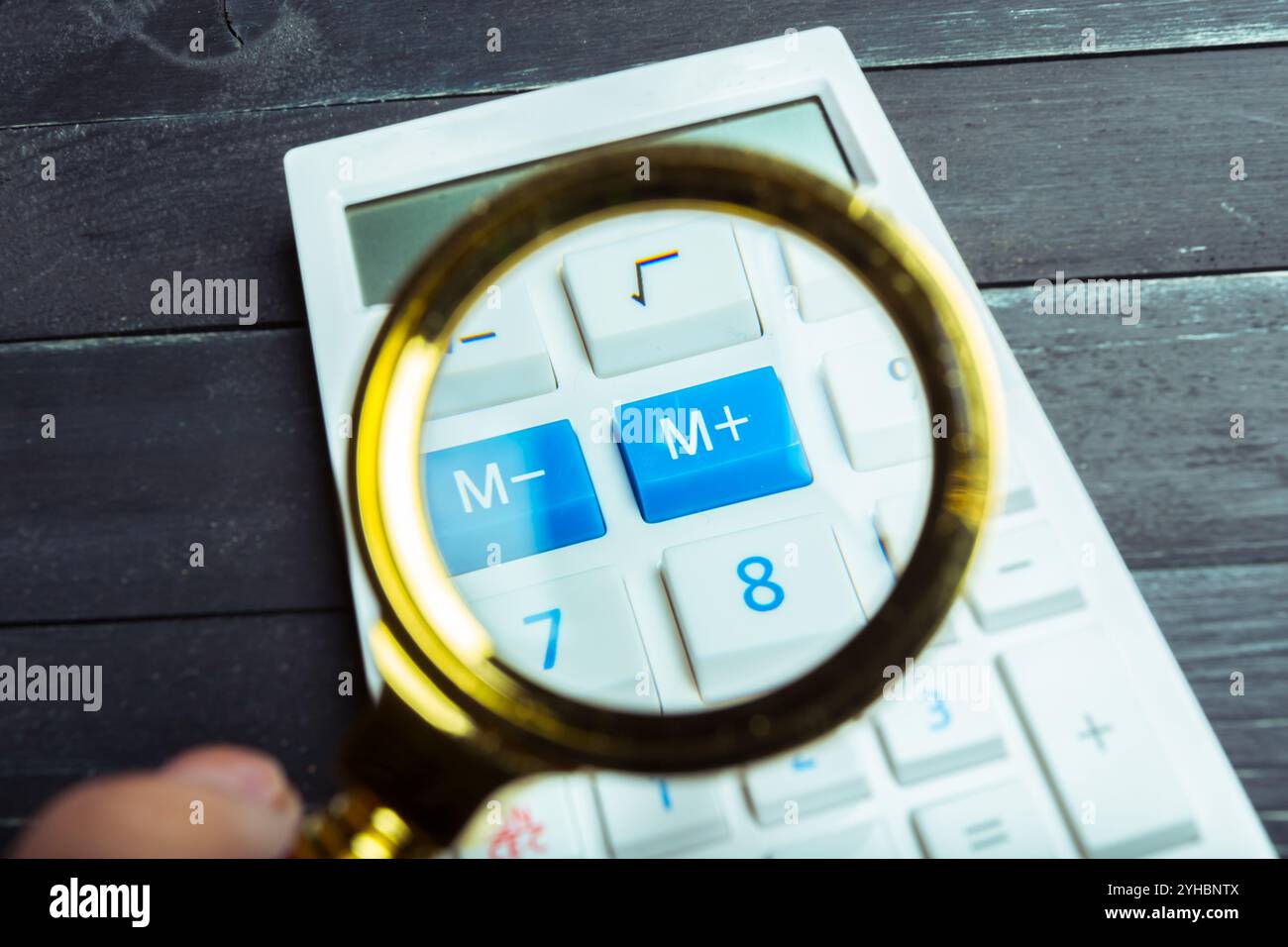 Calculator and magnifying glass Stock Photo - Alamy