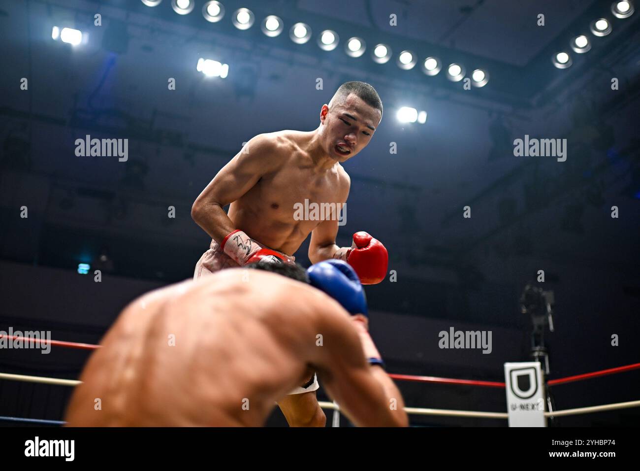 Riku Masuda (red gloves) knocks down Yoshihiro Utsumi (blue gloves) during their the Japanese ...
