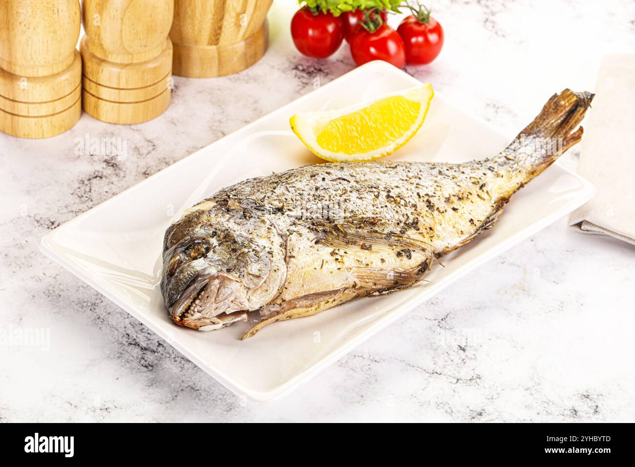Baked Dorado fish served lemon slice Stock Photo - Alamy