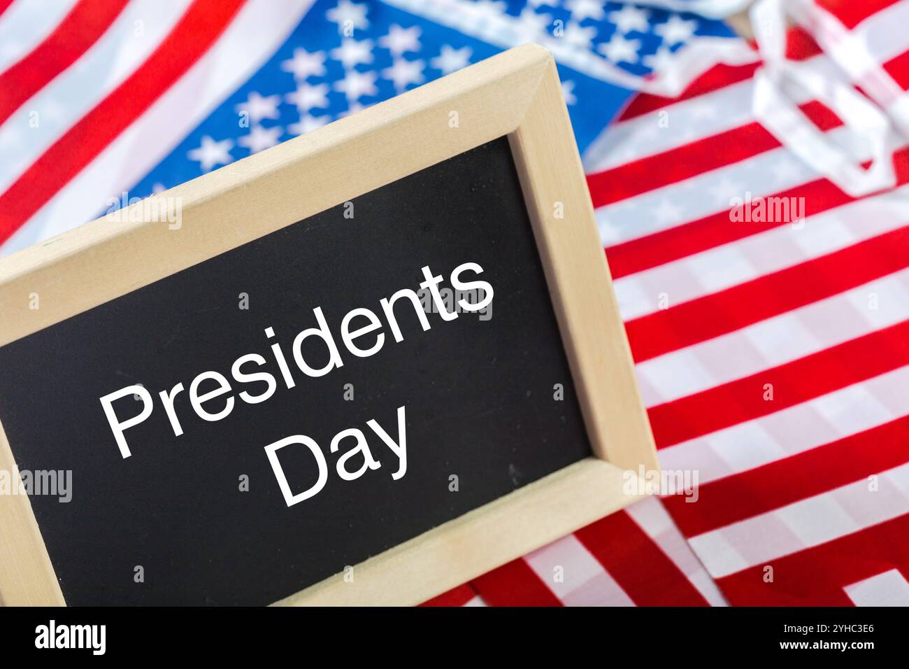 the text happy presidents day written in a chalkboard and a flag of the ...