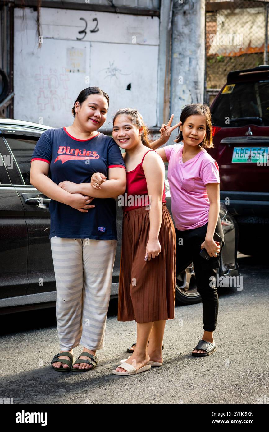 Three young Filipino girls pose for my camera in the street in the ...