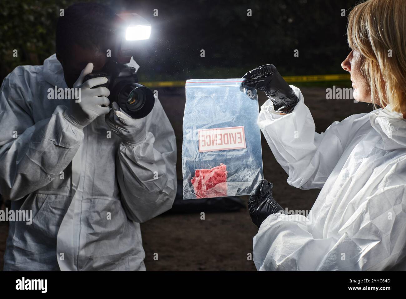 Scene of forensic investigators at work taking photos of evidence in ...