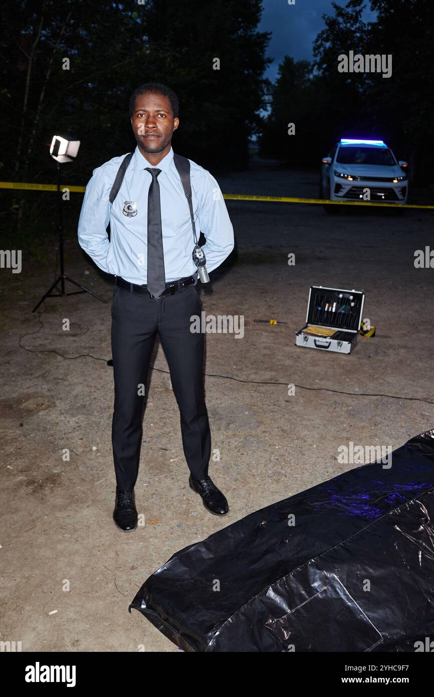 Vertical full length portrait of African American man as police officer ...