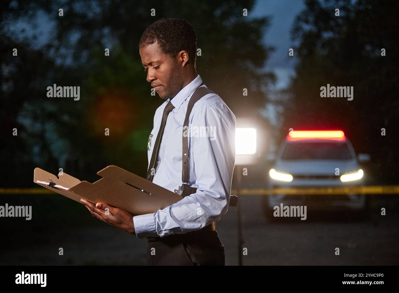 Side view portrait of African American police investigator reading ...