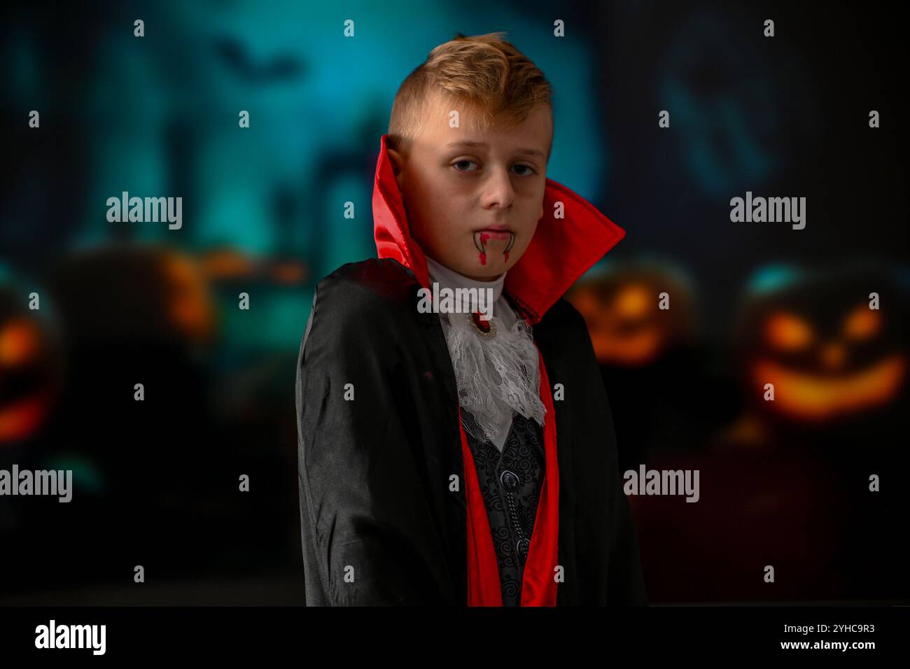 Child dressed as a vampire posing in front of a blurred background with ...