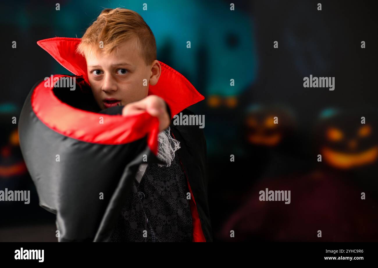 Child dressed as a vampire posing in front of a blurred background with ...