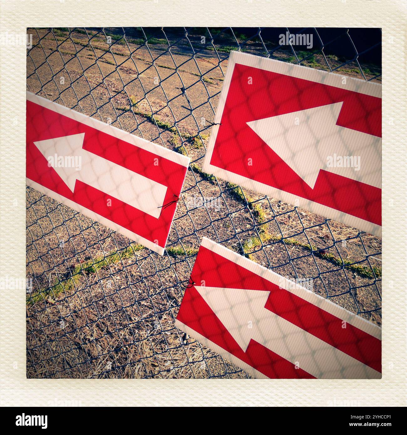 Three arrow signs on a cyclone fence surrounding a vacant lot - Fair ...