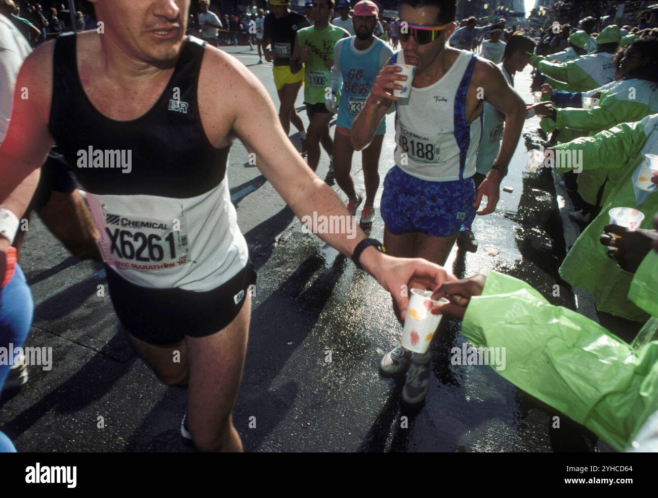 Runners grab water at a water station during the New York City Marathon ...