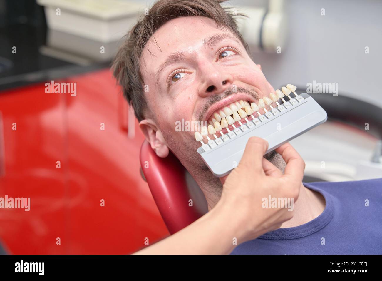 woman approaches sample teeth to see the shade of white of her teeth ...