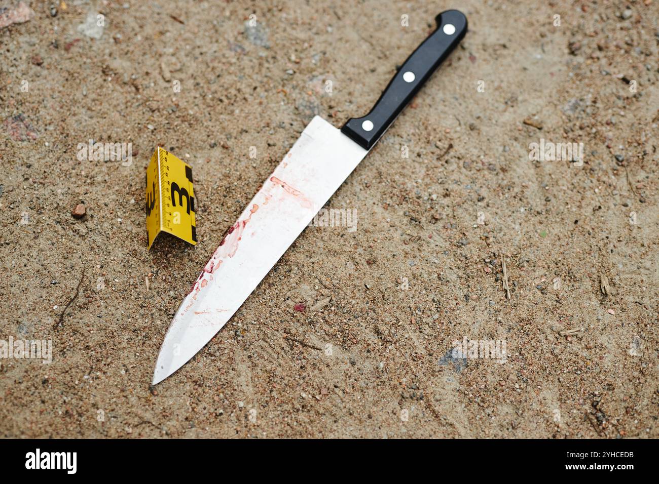 Top view of knife with red traces at crime scene as evidence tagged by ...