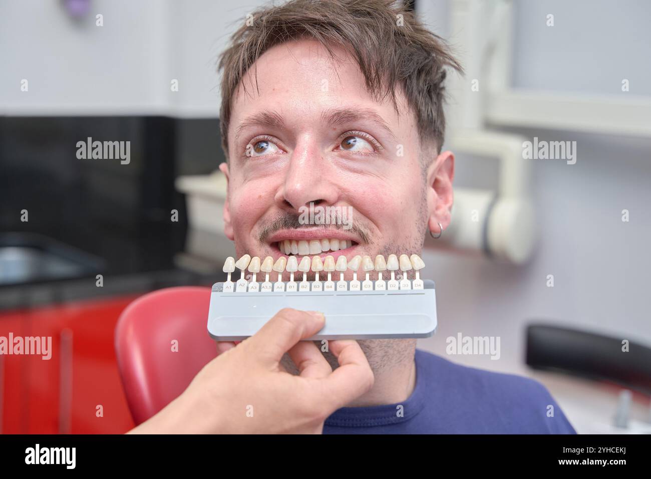 woman approaches sample teeth to see the shade of white of her teeth ...