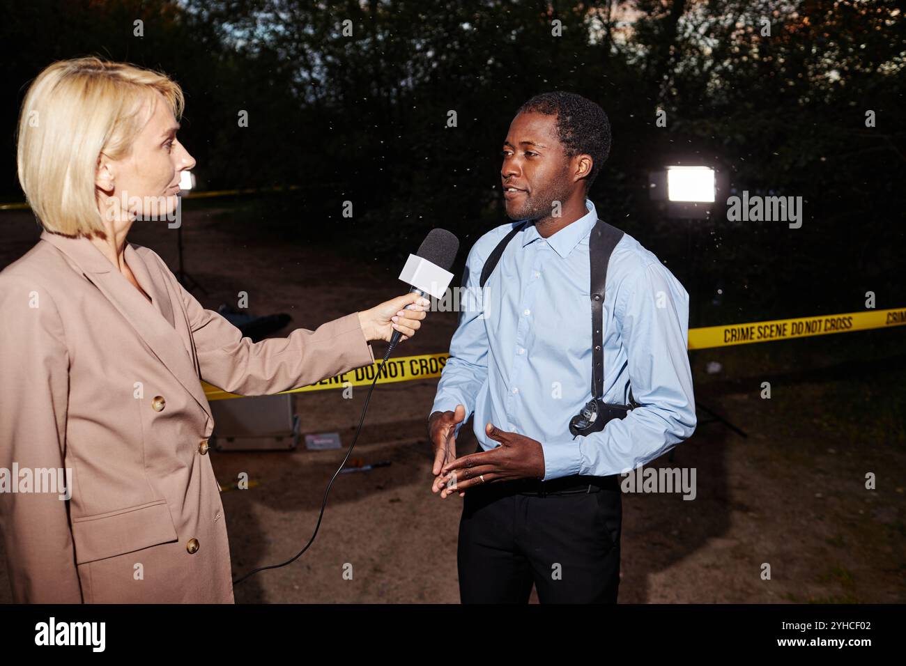 Waist up portrait of female reporter interviewing police officer ...