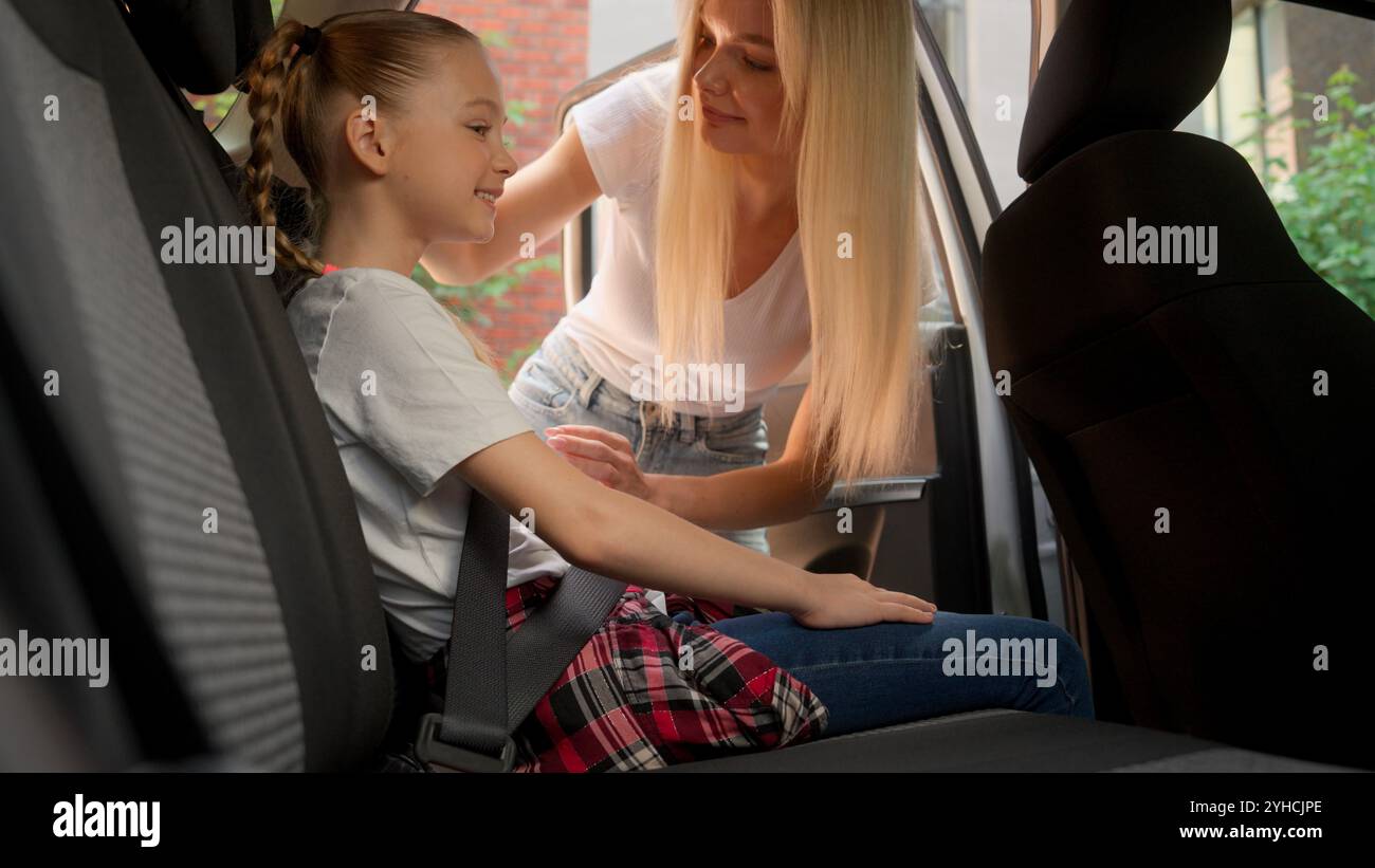 Happy family loving Caucasian woman female mother mom fastening seat ...