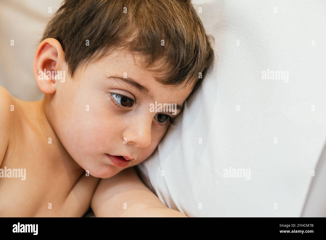 Sick child resting in bed, feeling unwell and needing comfort Stock ...