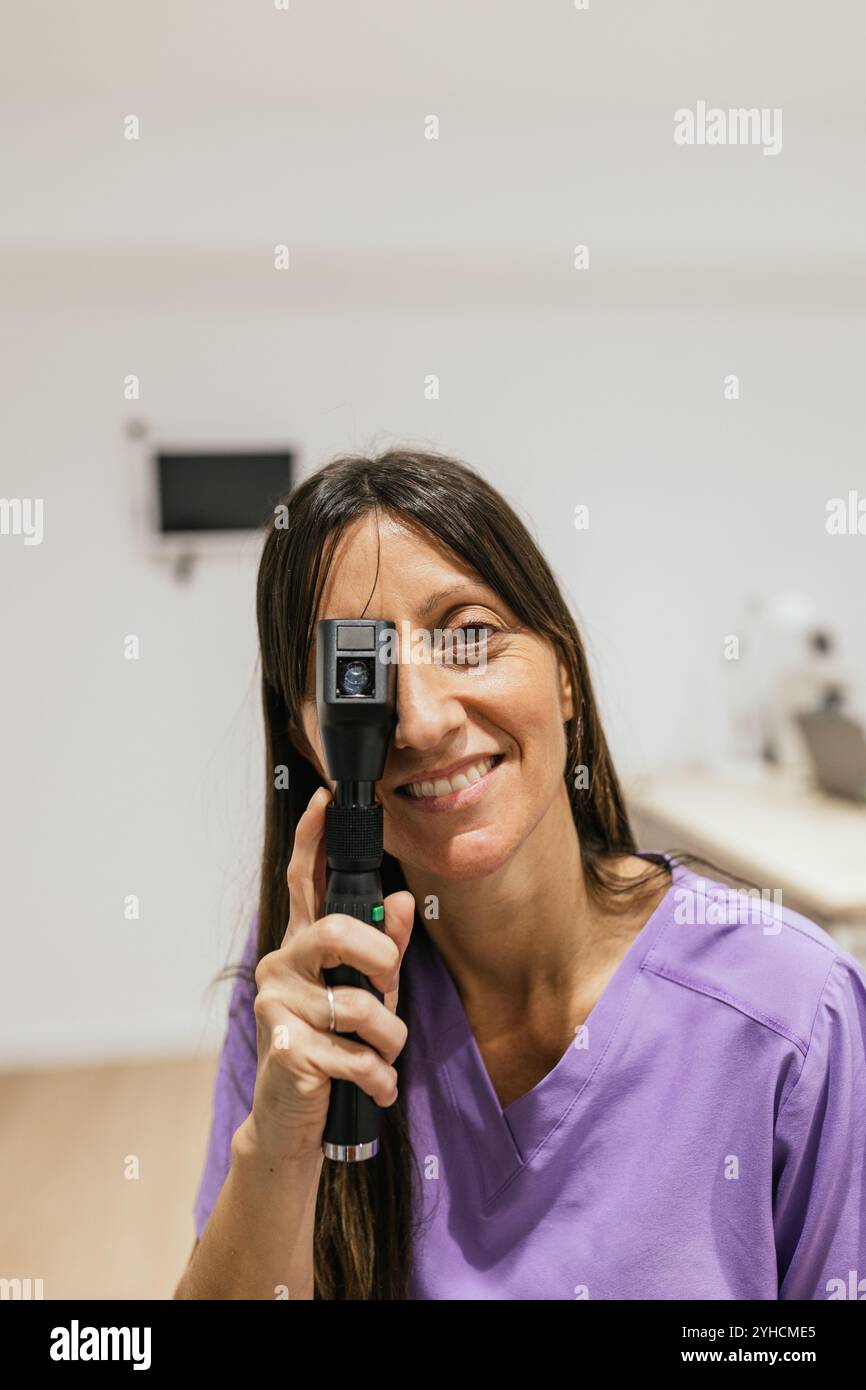 Female optometrist performing retinoscopy exam using retinoscope Stock ...