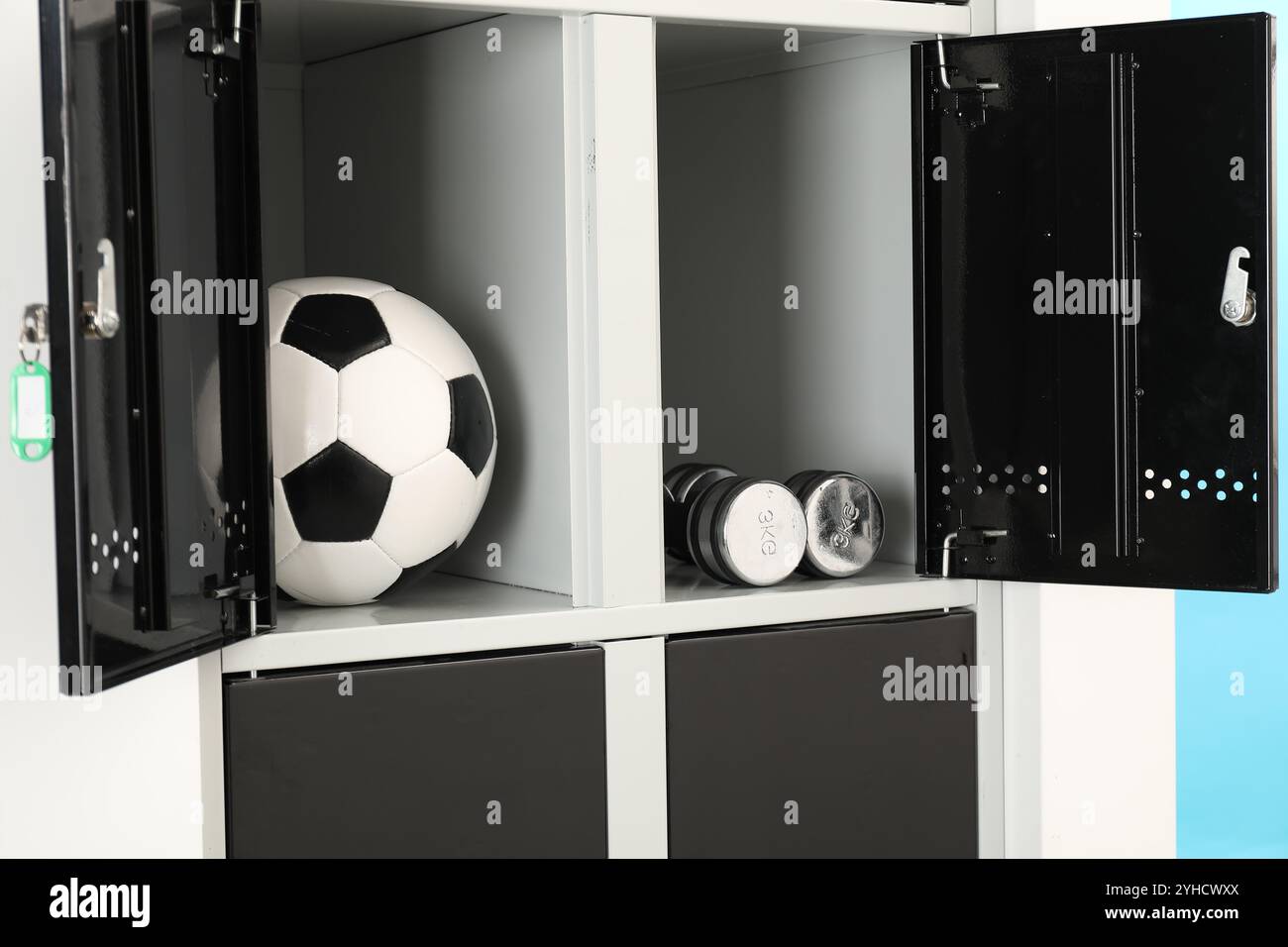 Open lockers with dumbbells and soccer ball on light blue background ...