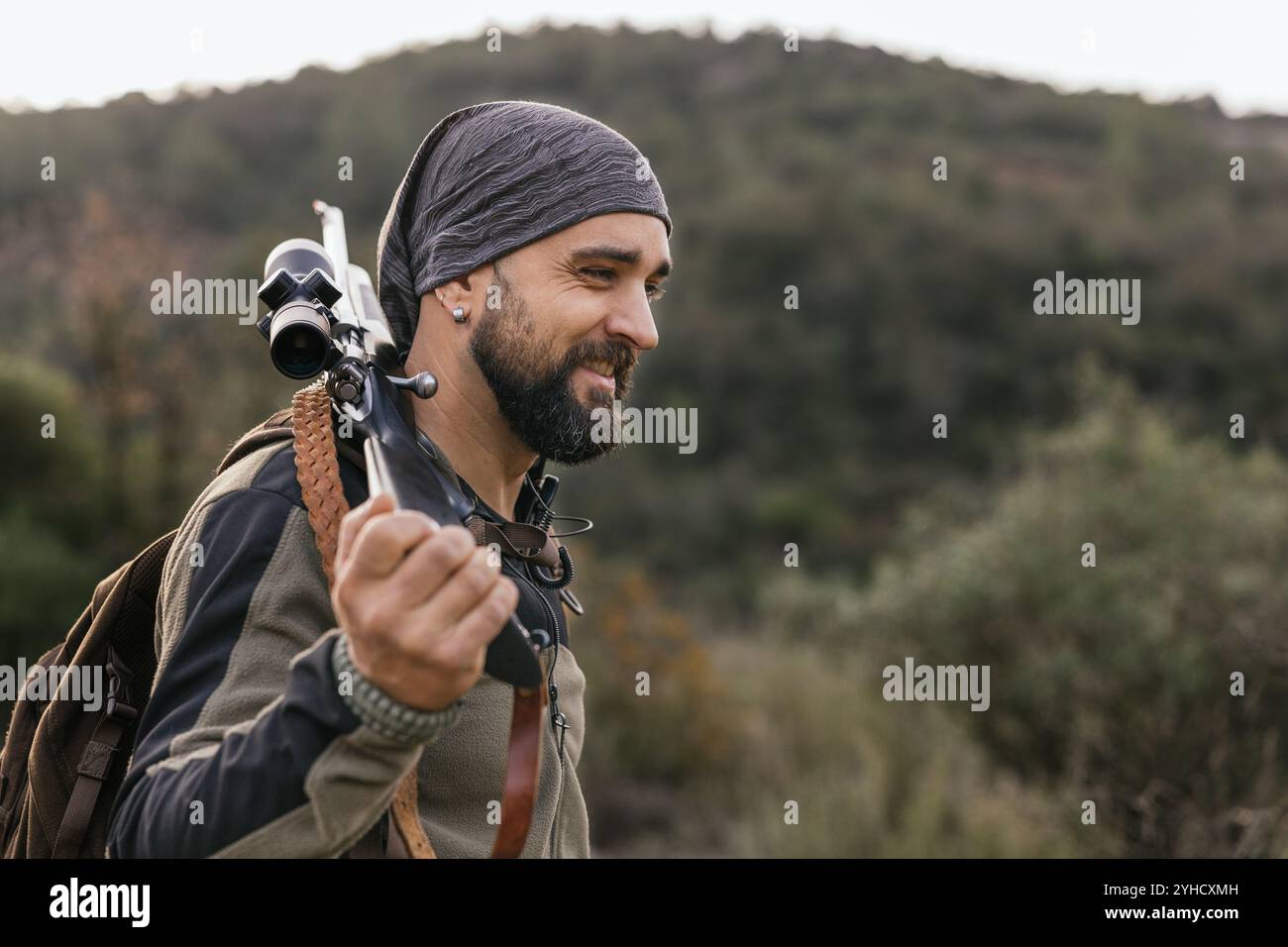 Hunter walking in nature carrying hunting rifle on shoulder Stock Photo ...