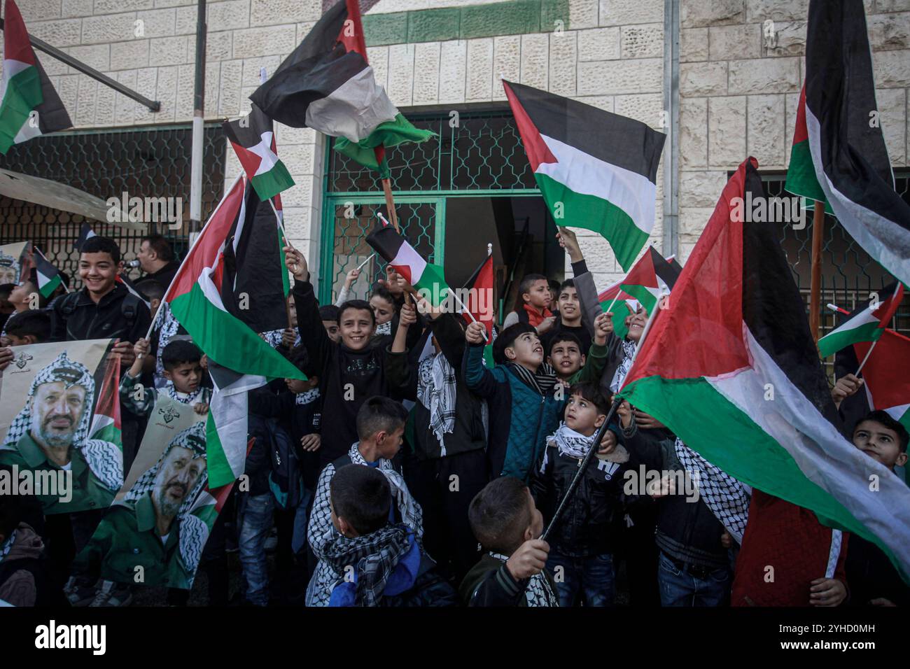 Palestinian school students wave Palestinian flags and pictures of late ...