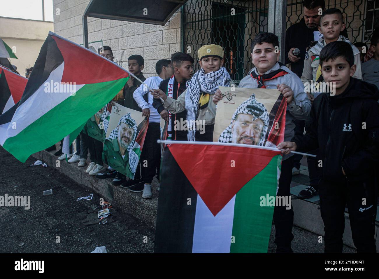 Palestinian school students wave Palestinian flags and pictures of late ...